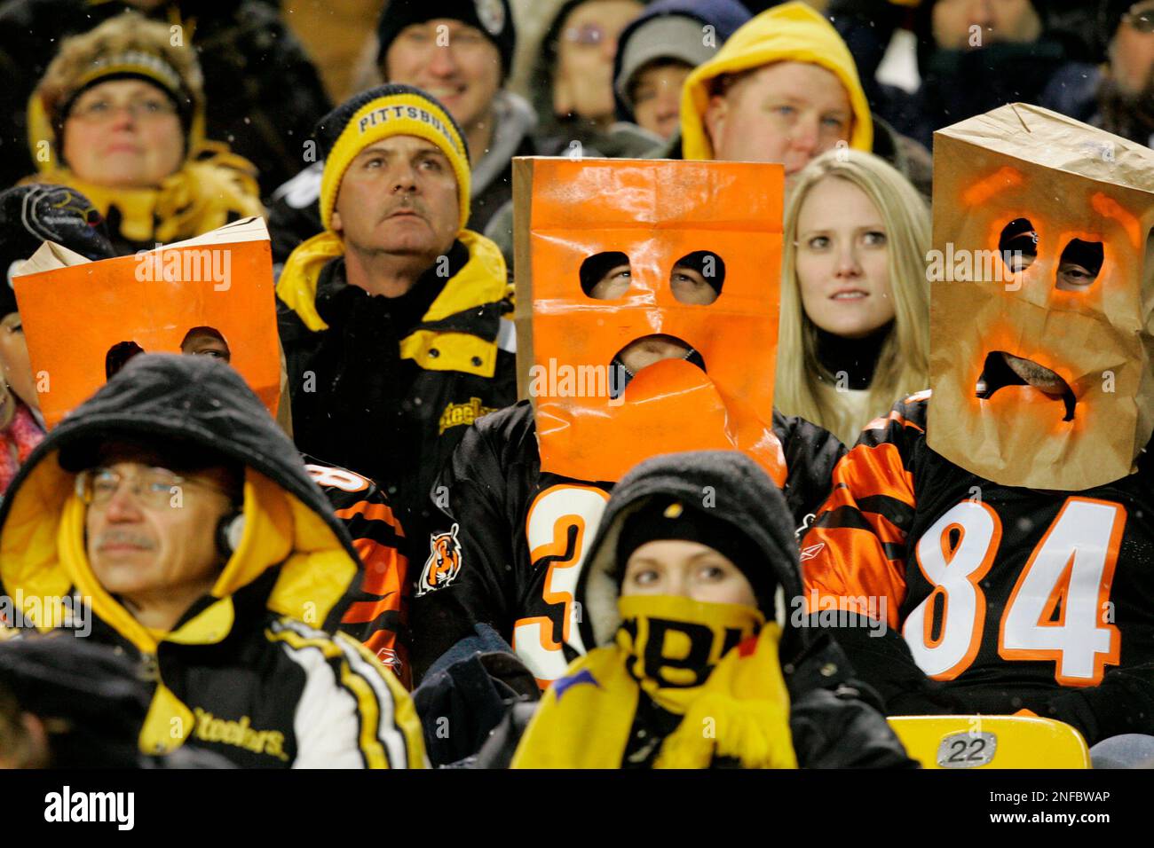Cincinnati Bengals fans sit with bags on their heads as they watch the ...