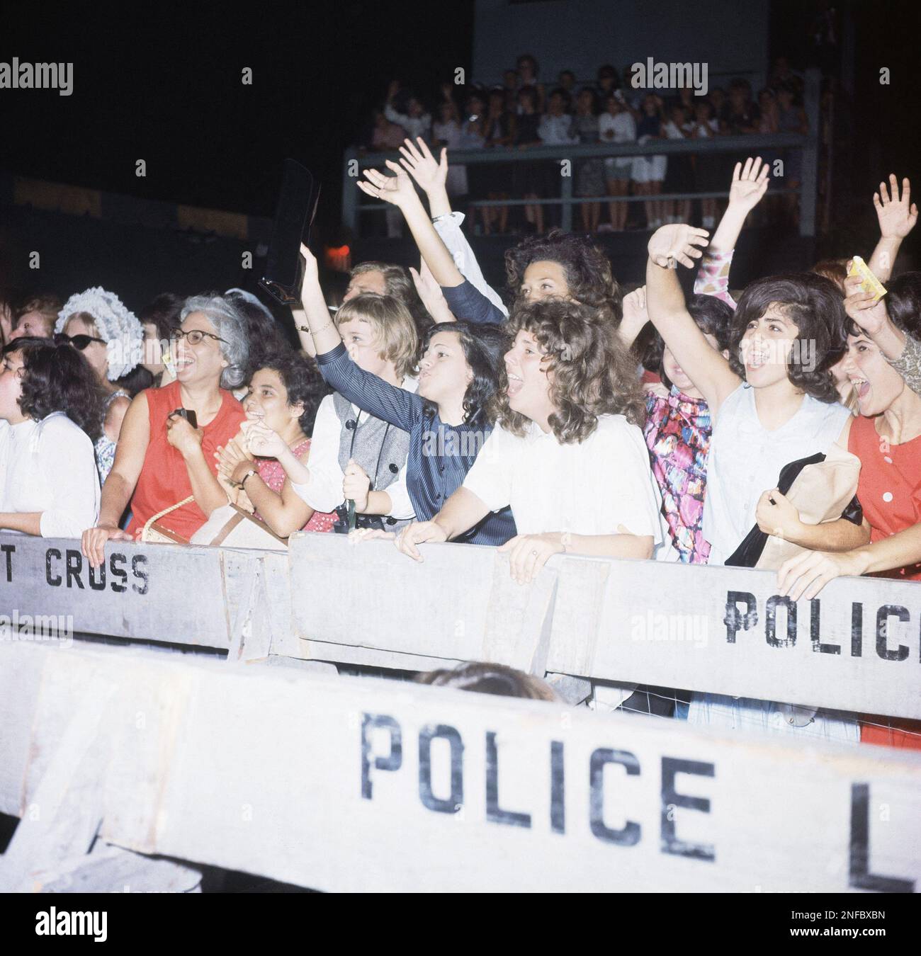 Fans of the British band the Beatles, scream from behind police ...