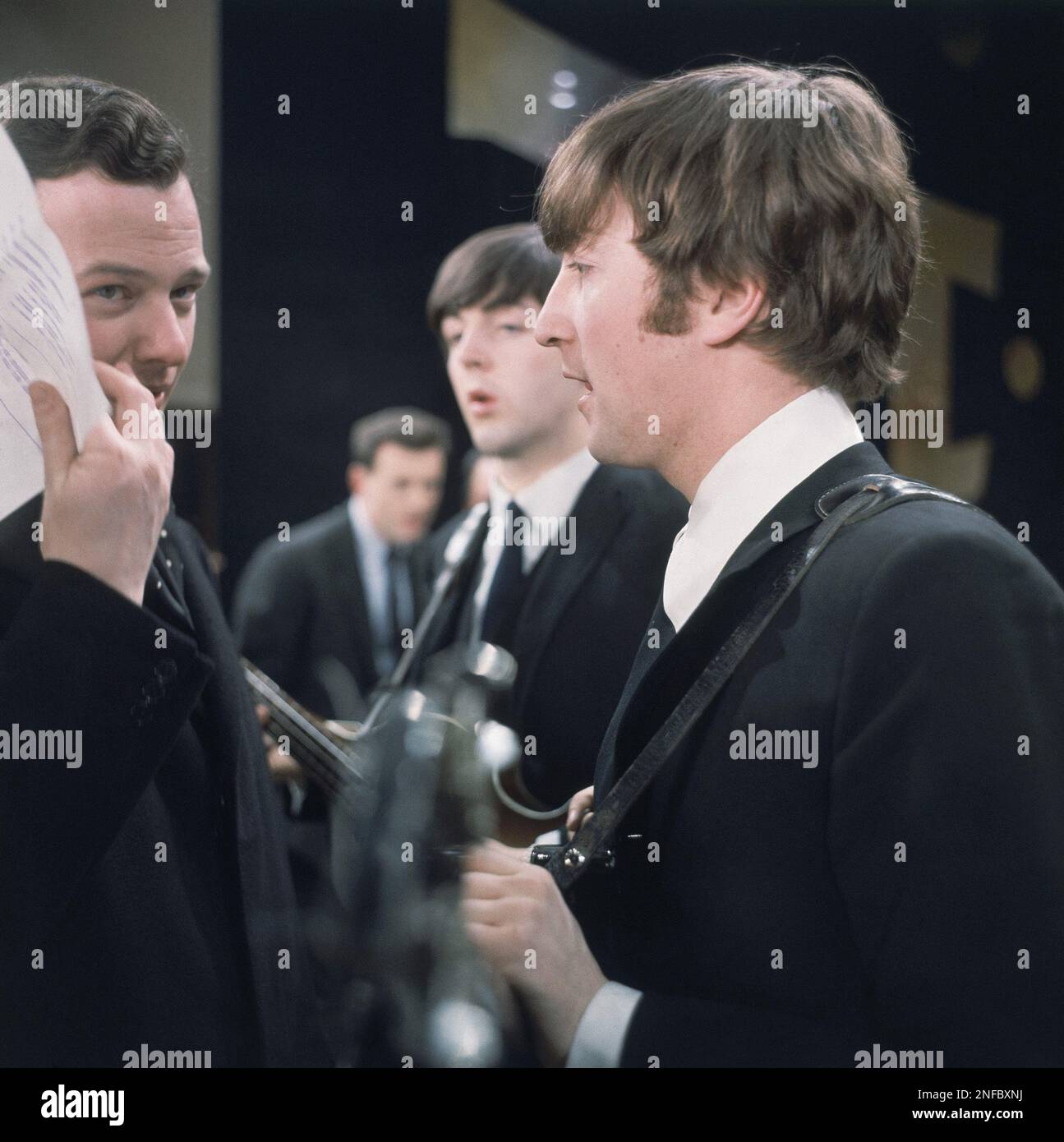 John Lennon of the Beatles is shown backstage speaking with manager ...