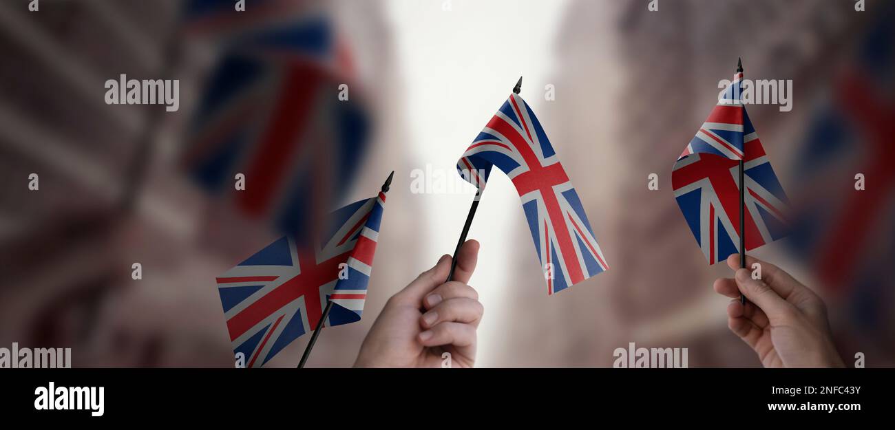 A group of people holding small flags of the United Kingdom in their ...