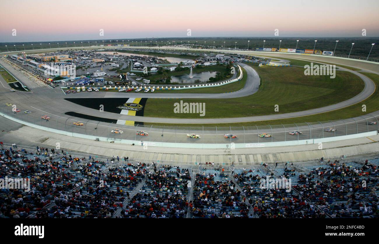 NASCAR racers follow the pace car during a caution in the Ford 400 auto ...