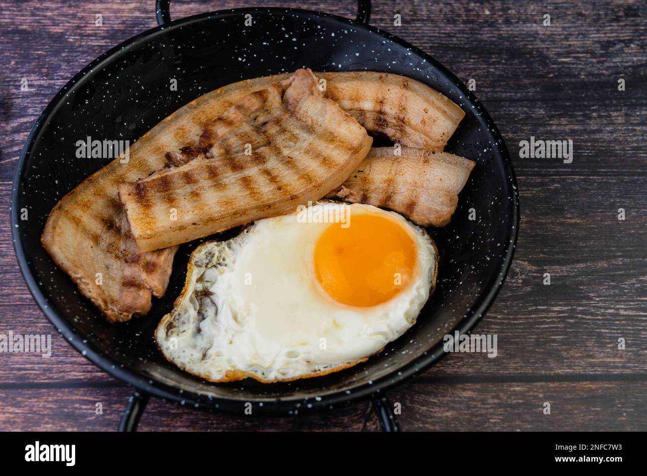 A close-up image of a traditional breakfast dish of crisp bacon strips ...