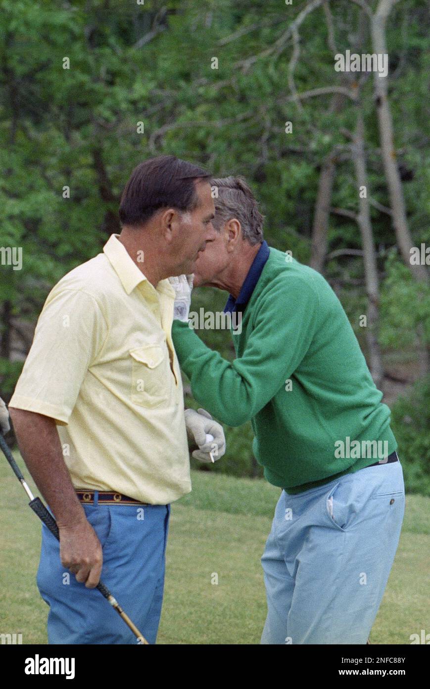 President George Bush whispers in the ear of Spike Heminway, a longtime ...