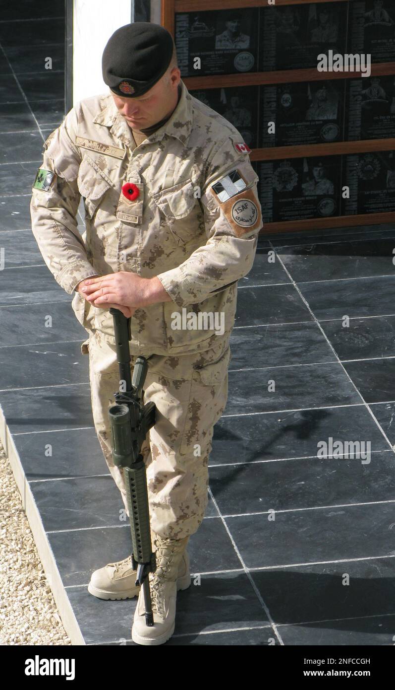 A Canadian soldier stands with his head bowed prior to the beginning of ...