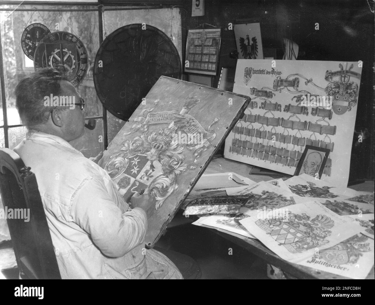 Karl Busch studies the coat of arms of the Schirach family and behind ...