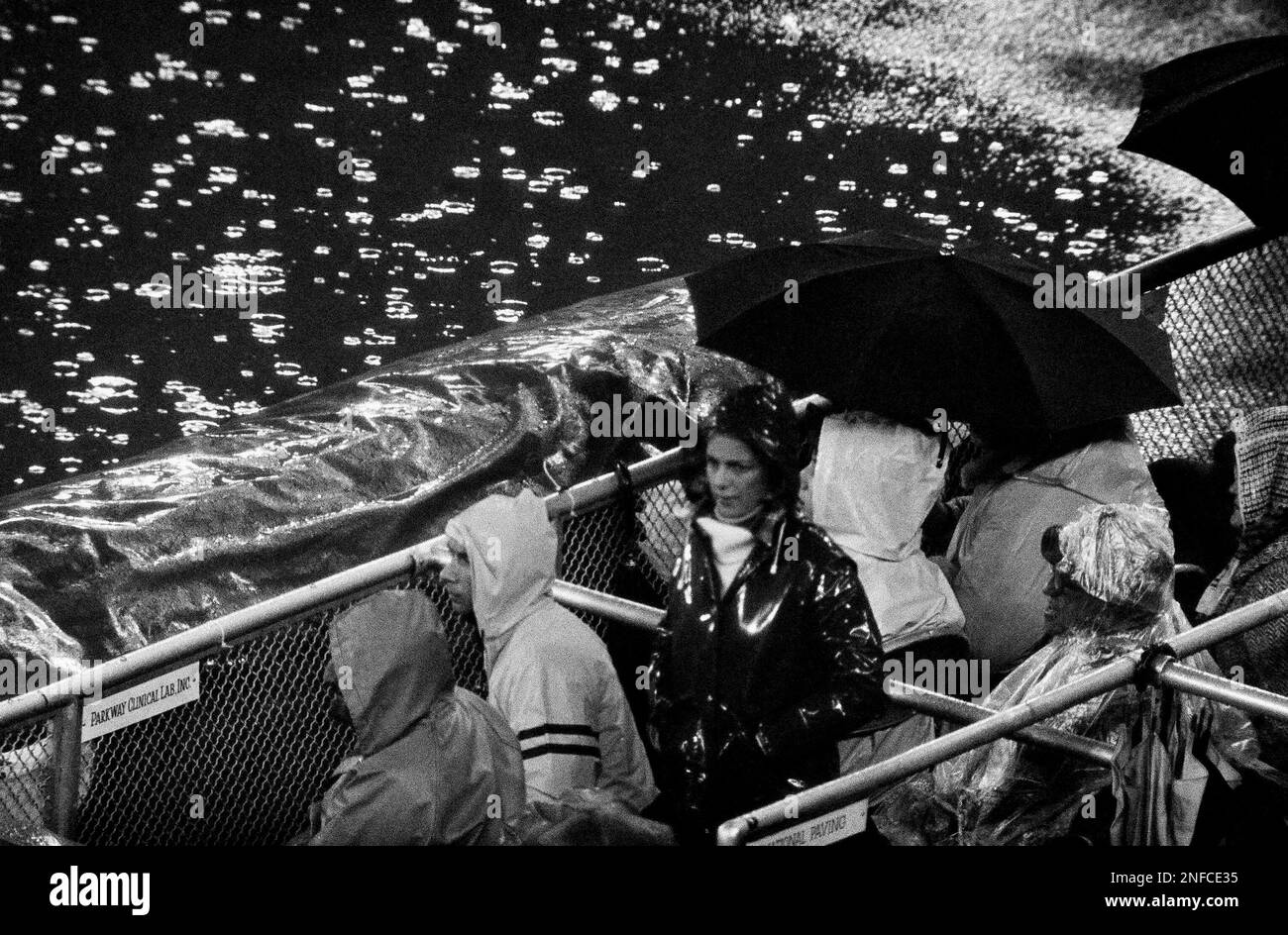 Raindrops make little circles in the puddles on the warning track ...