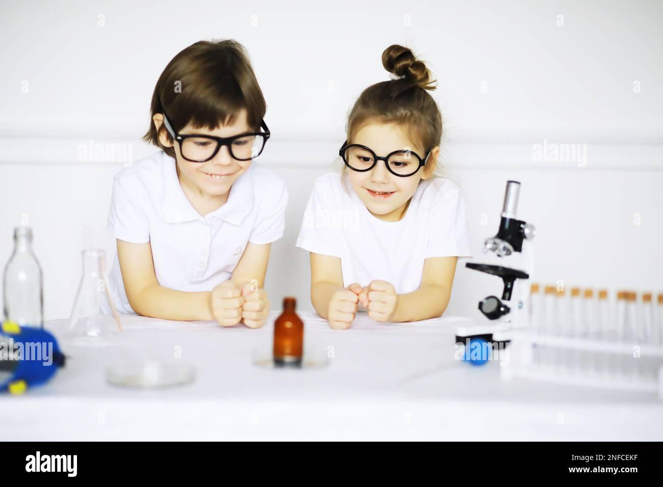 Two cute children at chemistry lesson making experiments isolated on ...