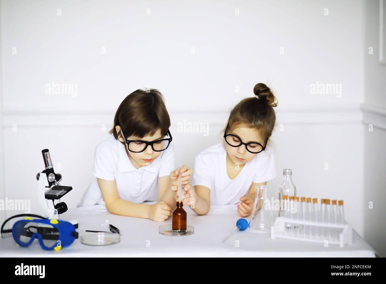 Two cute children at chemistry lesson making experiments isolated on ...