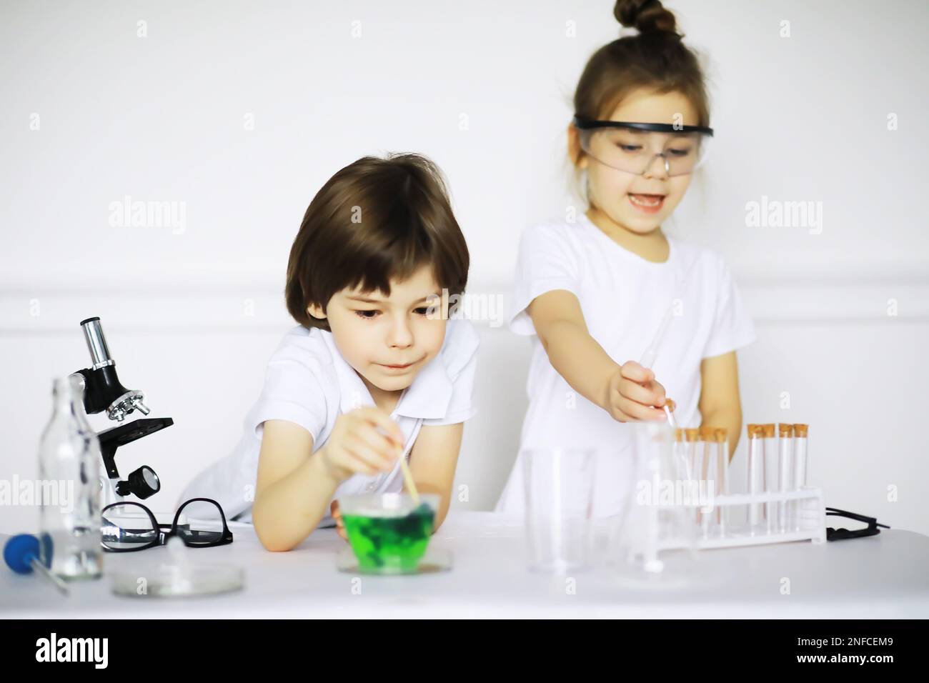 Two cute children at chemistry lesson making experiments isolated on ...