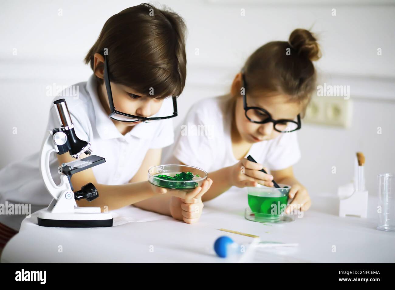 Two cute children at chemistry lesson making experiments isolated on ...