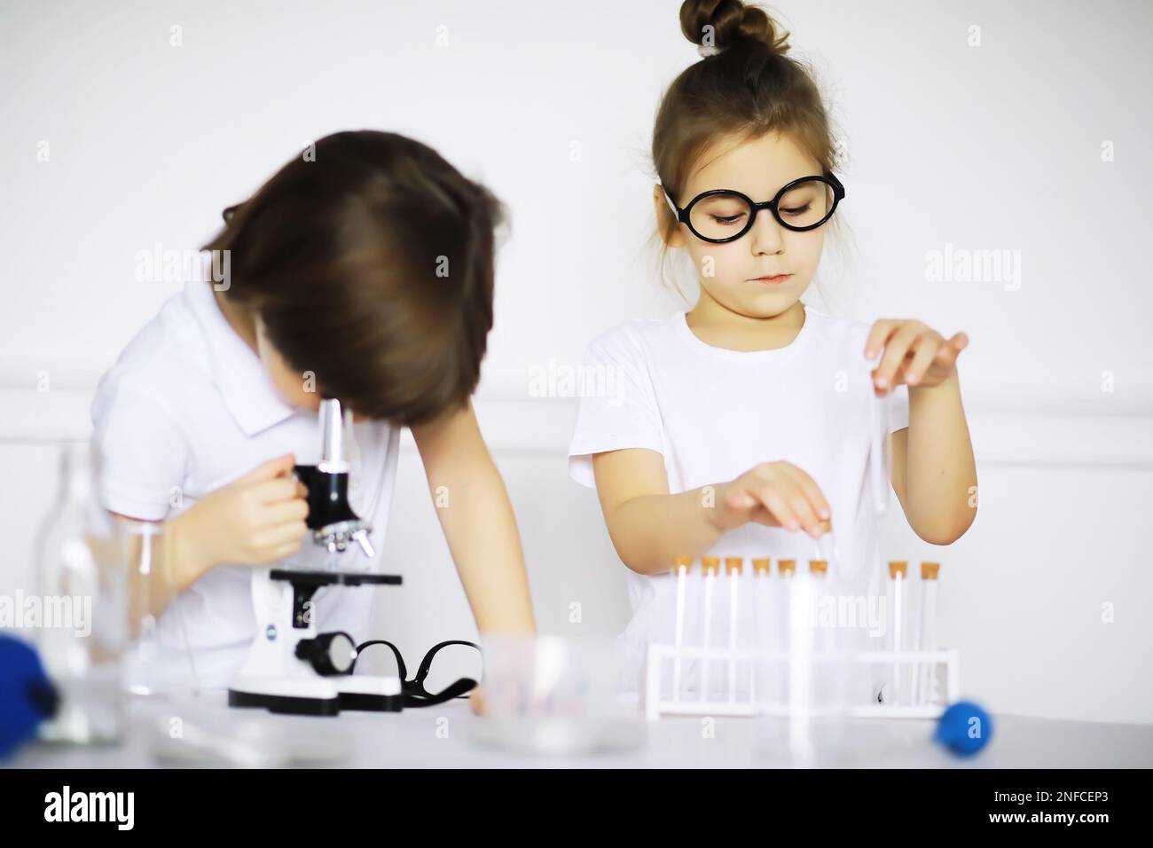Two cute children at chemistry lesson making experiments isolated on white background Stock ...