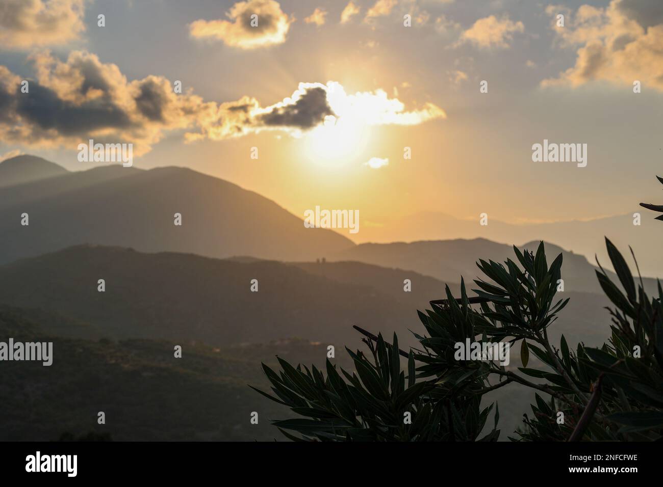 Majestic Cretan mountains with the sun setting behind, casting a warm ...
