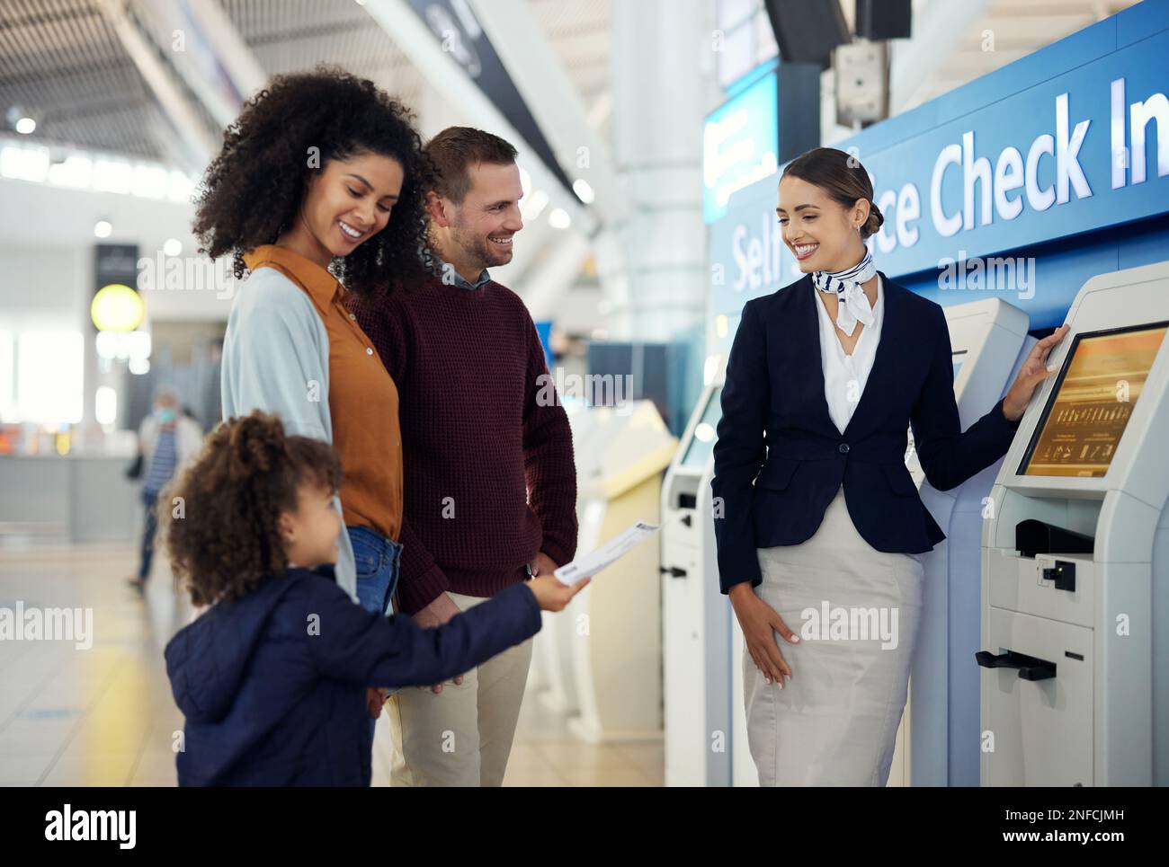 Woman, services agent and family at airport by self service check in ...