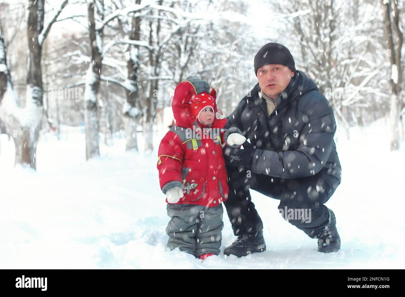 Family with children in the park in winter snow blizzard Stock Photo ...