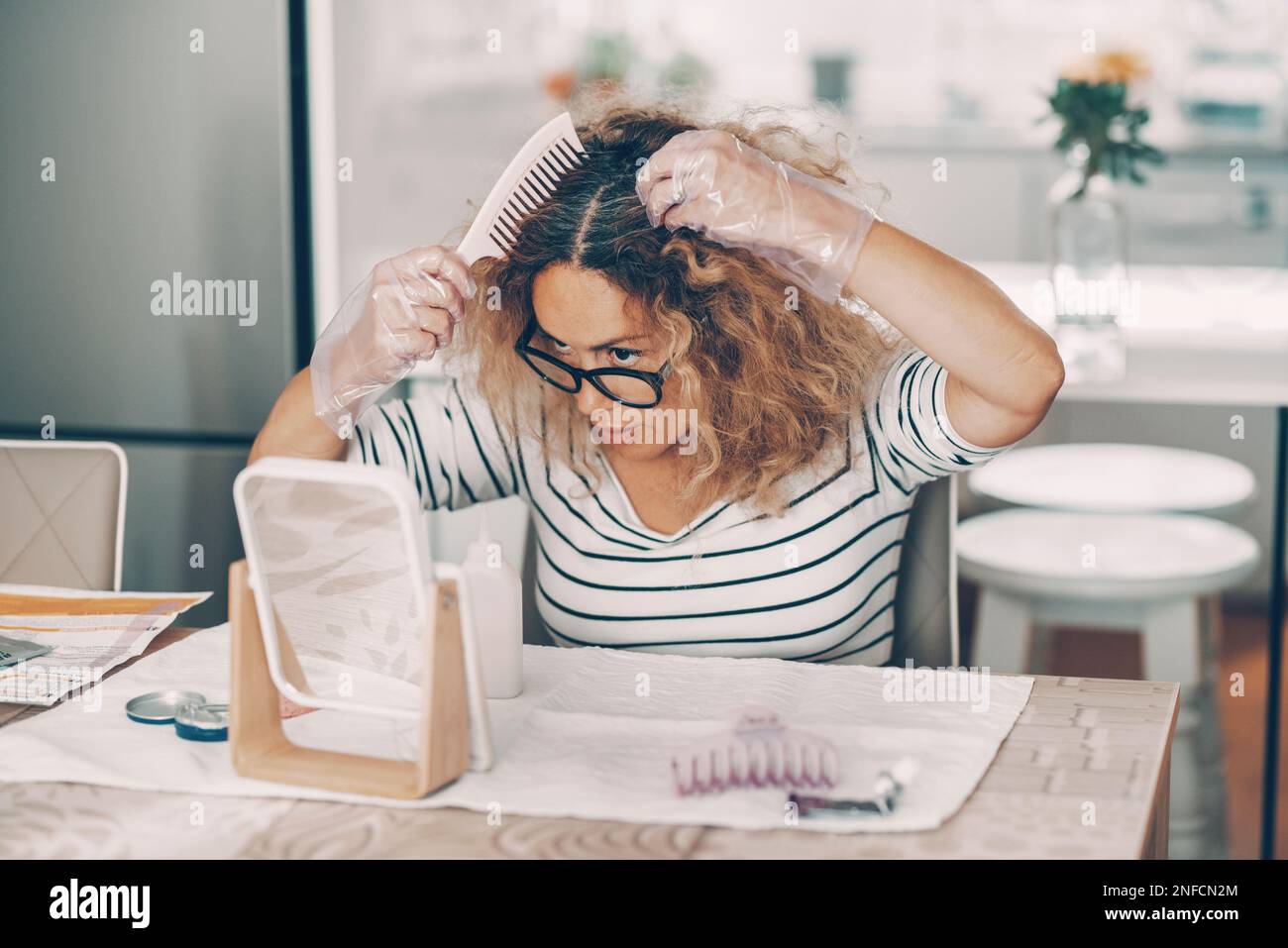 Young mature lady at home having care of her long hair looking for ...