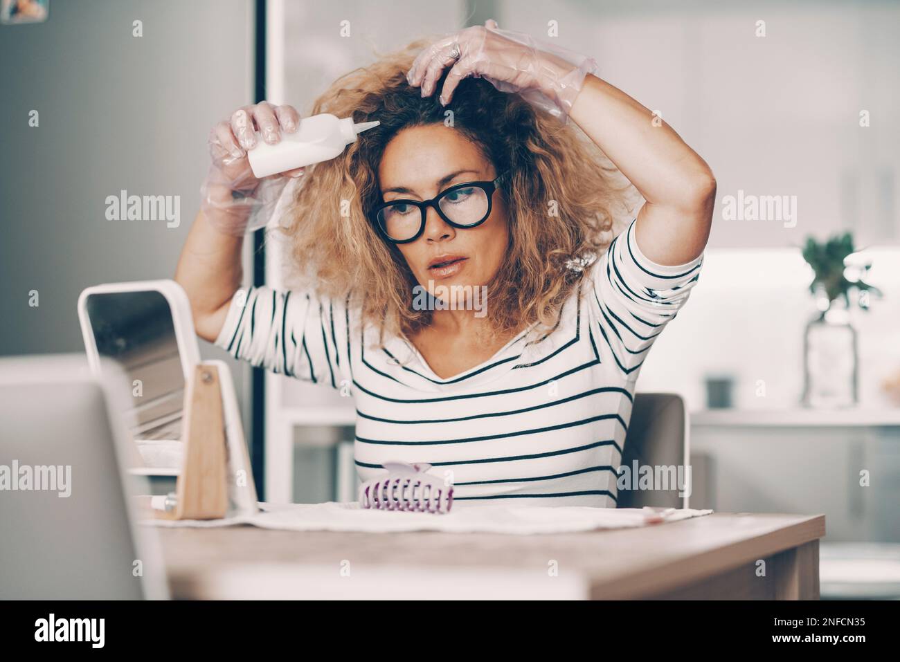 One long hair woman at home alone using chemical or natural products to ...