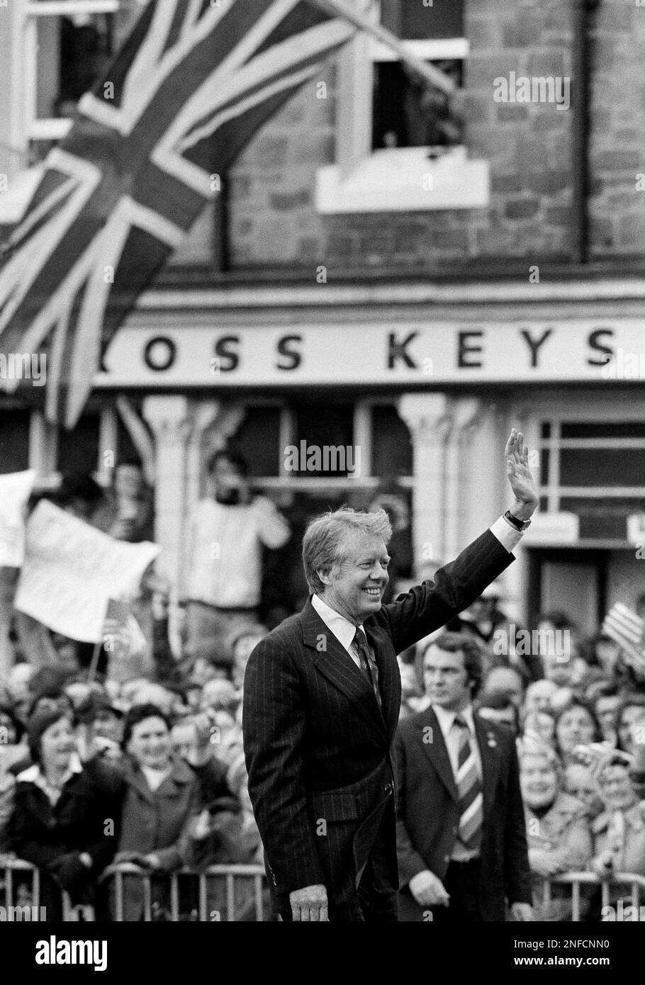 Under a Union Jack flag, President Jimmy Carter waves to the crowd ...