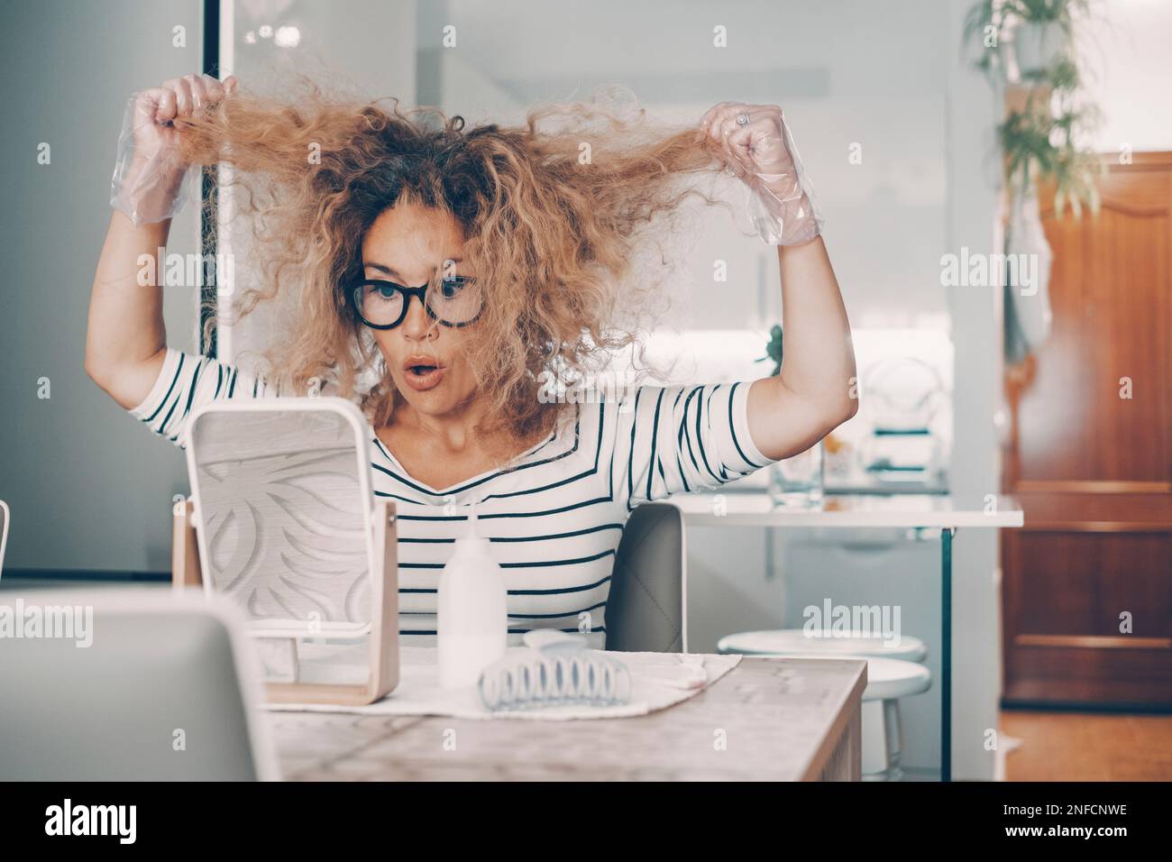 One young woman at home looking bad condition of her hair ready to use ...