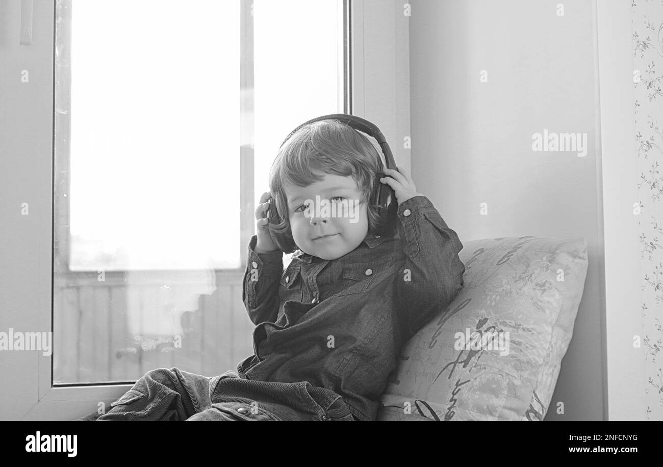 ittle child listens in the headphones music black and white photo Stock ...