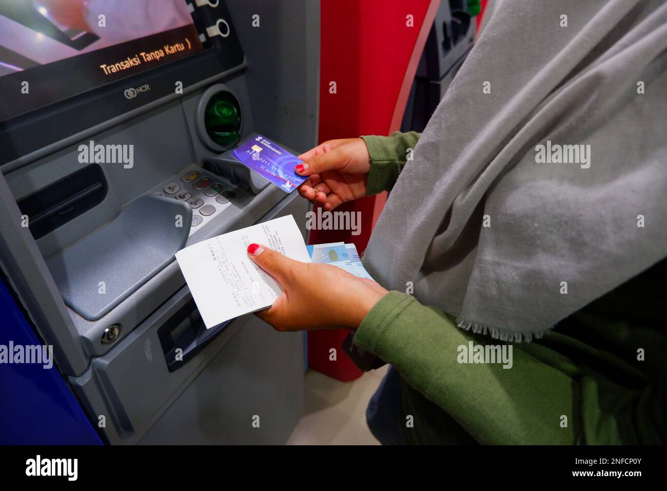 The Hand Of An Asian Woman Inserting A Card Into An Atm Machine, In ...