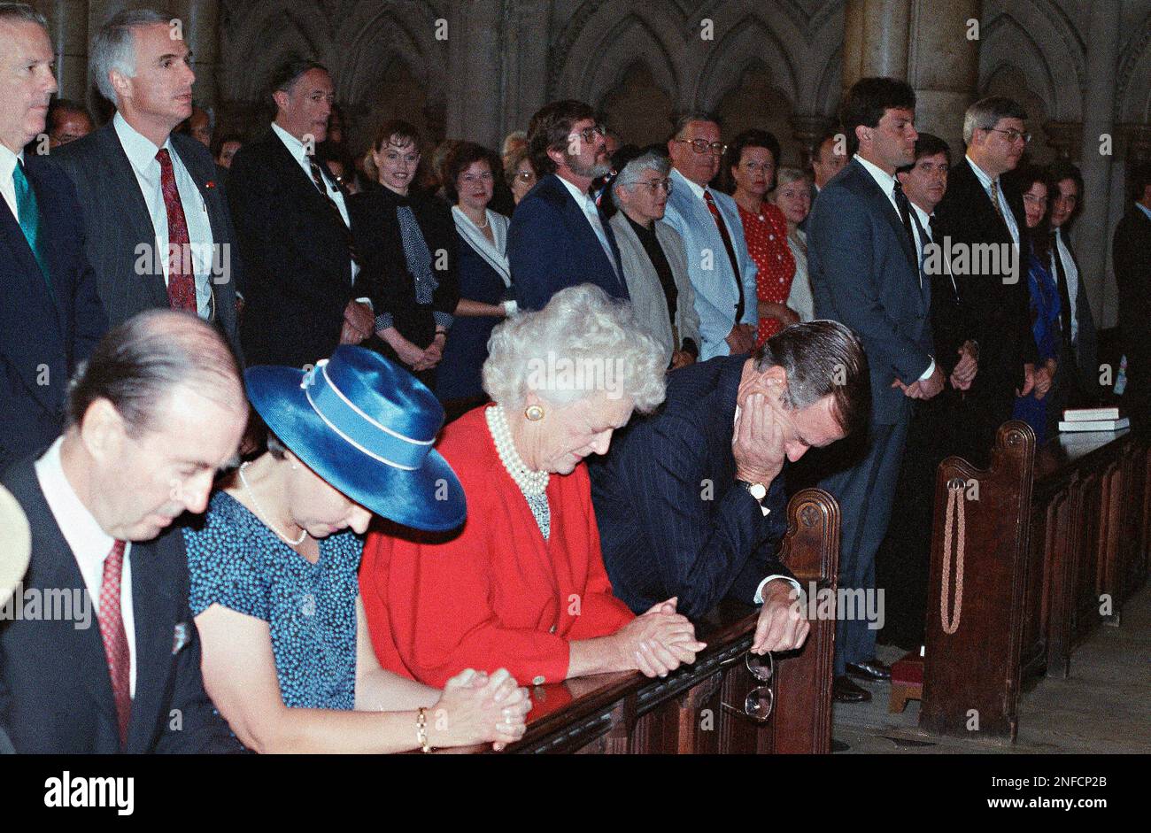 U.S. President George Bush and first lady Barbara Bush kneel in prayer ...