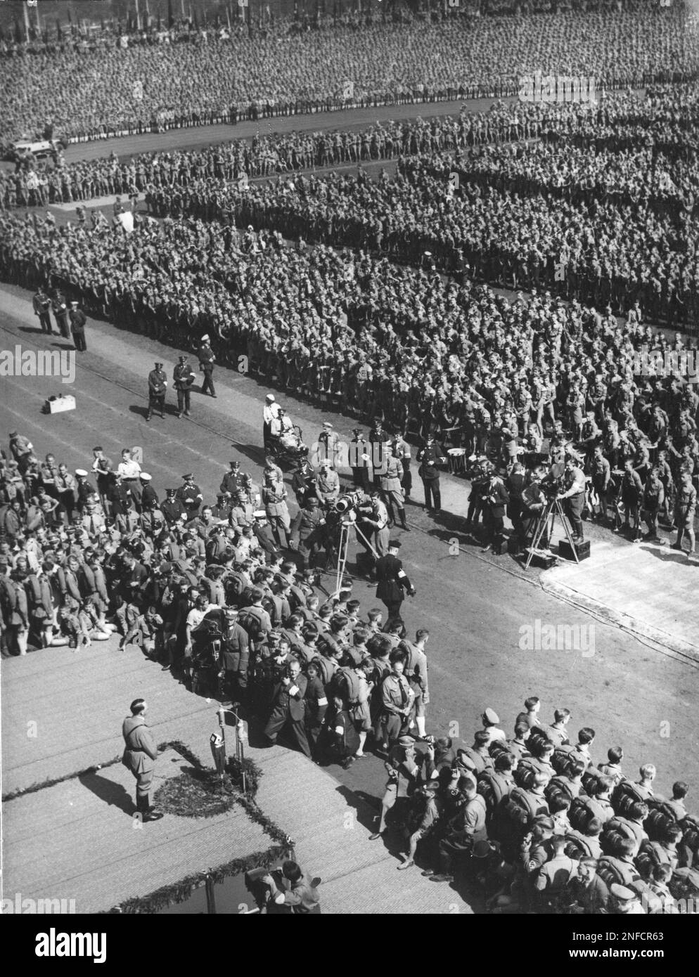Adolf Hitler is pictured standing on a stage in the stadium in ...