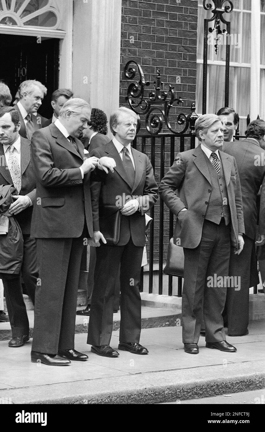 Britain's Prime Minister James Callaghan, left, checks his watch as he ...