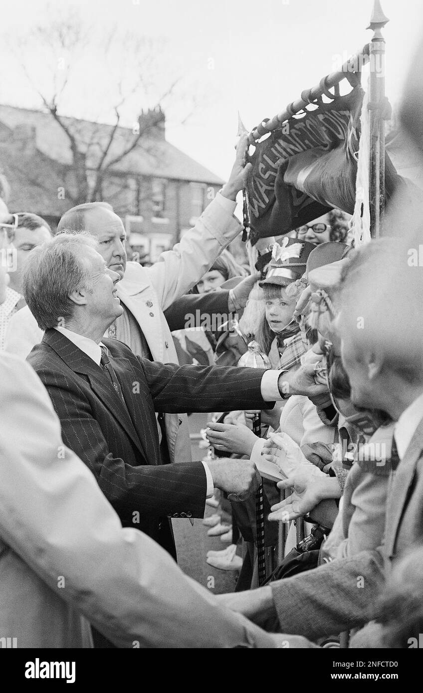 Pres. Jimmy Carter, left, looks up as a secret service agent helps to ...