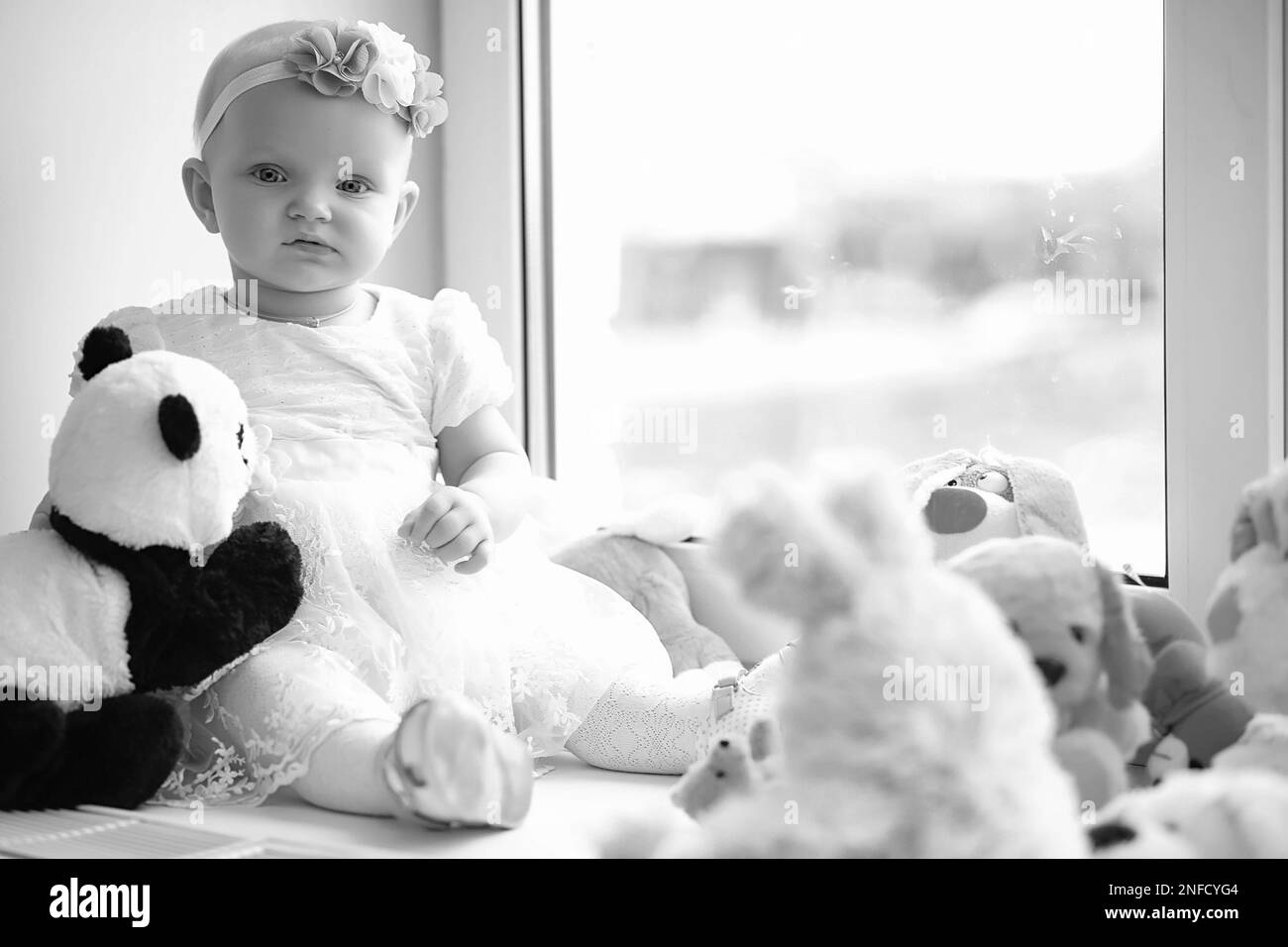 Child in the children's room. The kid is sitting on the windowsill at ...