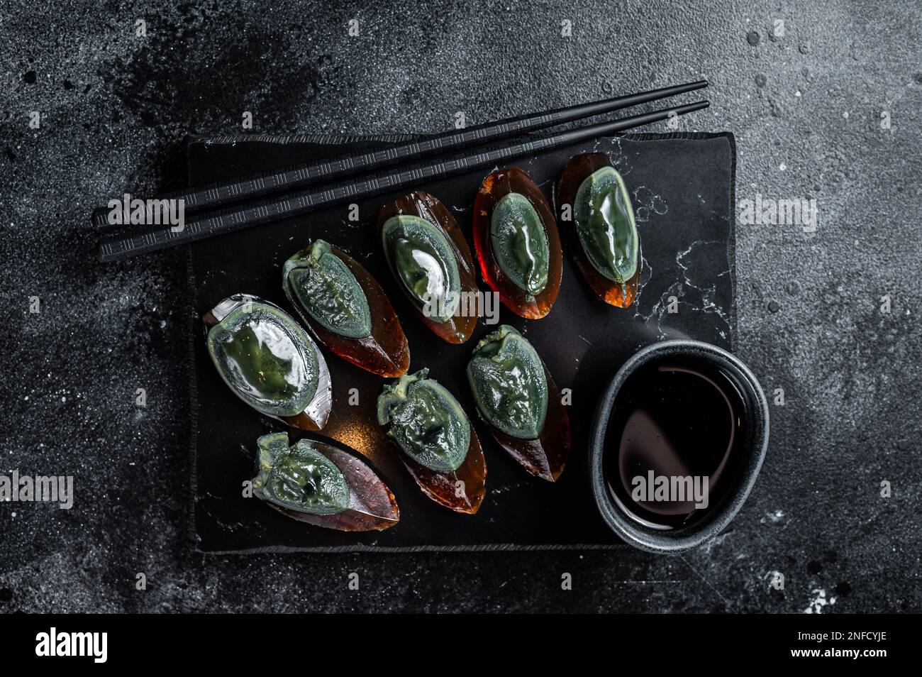 Chinese Century eggs, black egg is cut showing dark yolk. Black ...