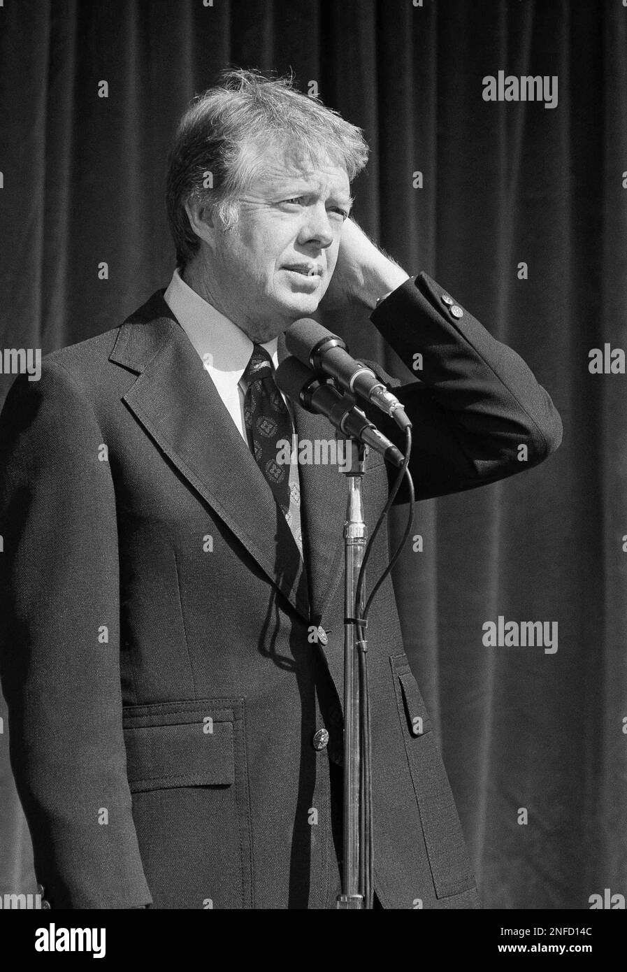 Pres. Jimmy Carter keeps brushing his hair with his hands while ...