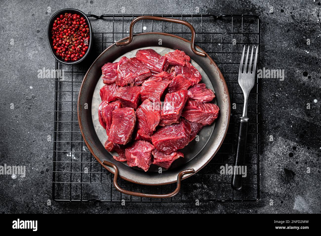 Raw Diced venison dear meat for a goulash, game meat. Black background ...