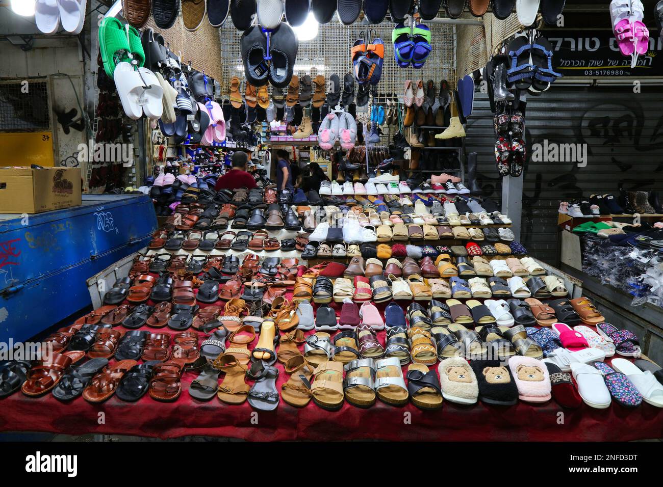 TEL AVIV, ISRAEL - NOVEMBER 2, 2022: Shoe seller at Carmel Market in ...