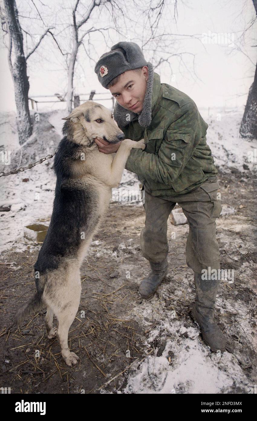 A Russian soldier plays with a dog near a checkpoint on the border with ...
