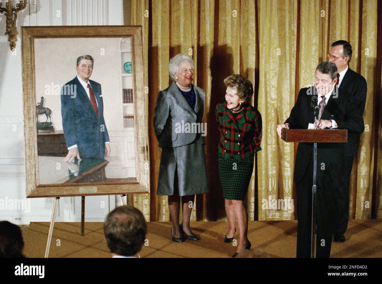 Former President Ronald Reagan and wife Nancy take a peek at a portrait ...