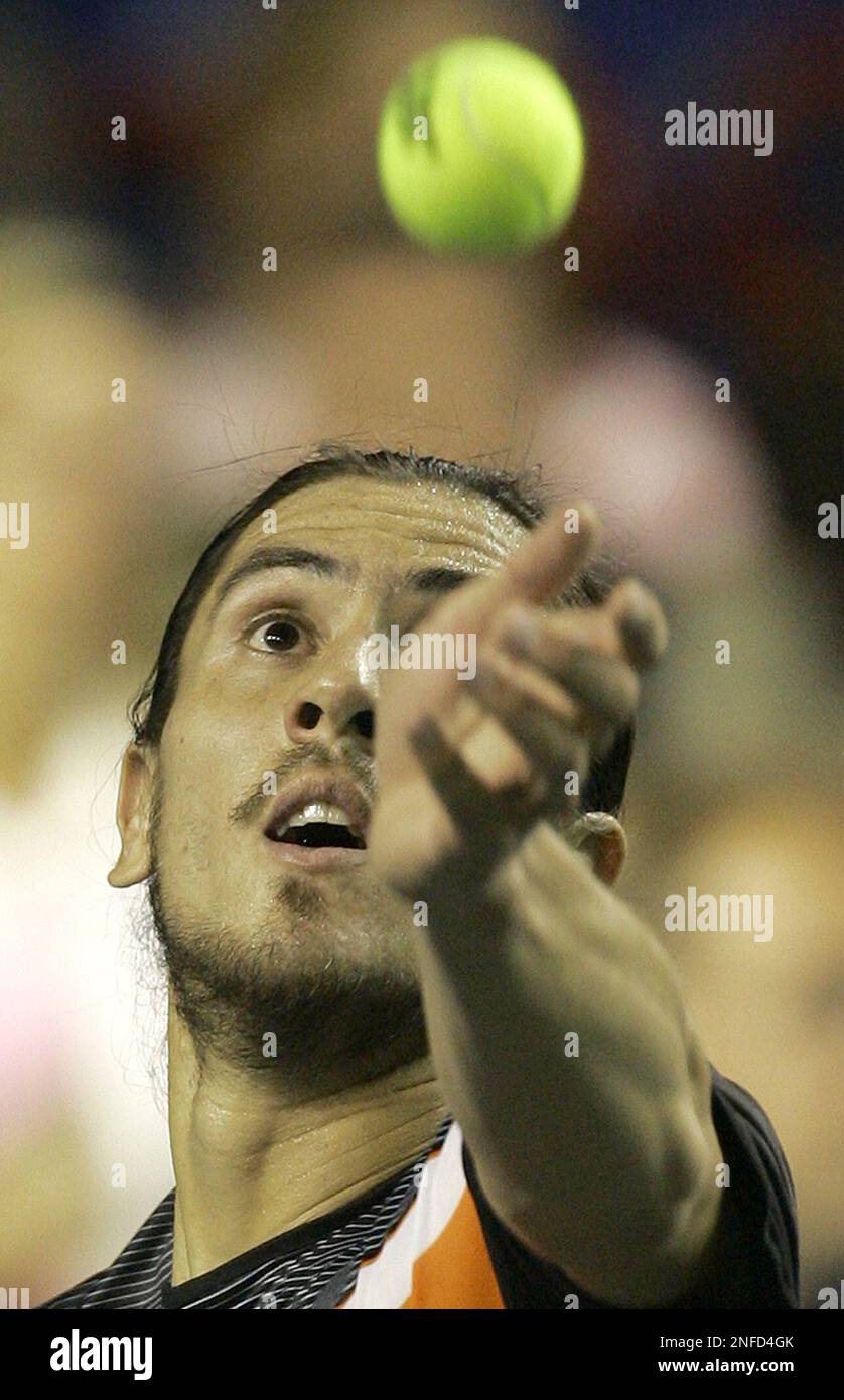 Guillermo Canas of Argentina serves the ball to Florent Serra of France ...