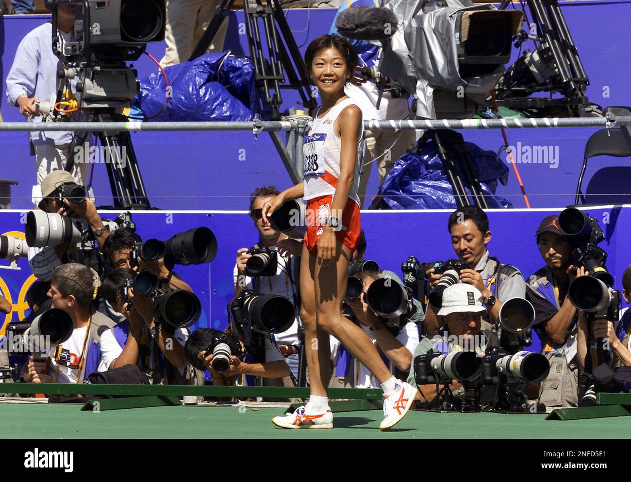 Naoko Takahashi of Japan walks past photographers after she won the ...