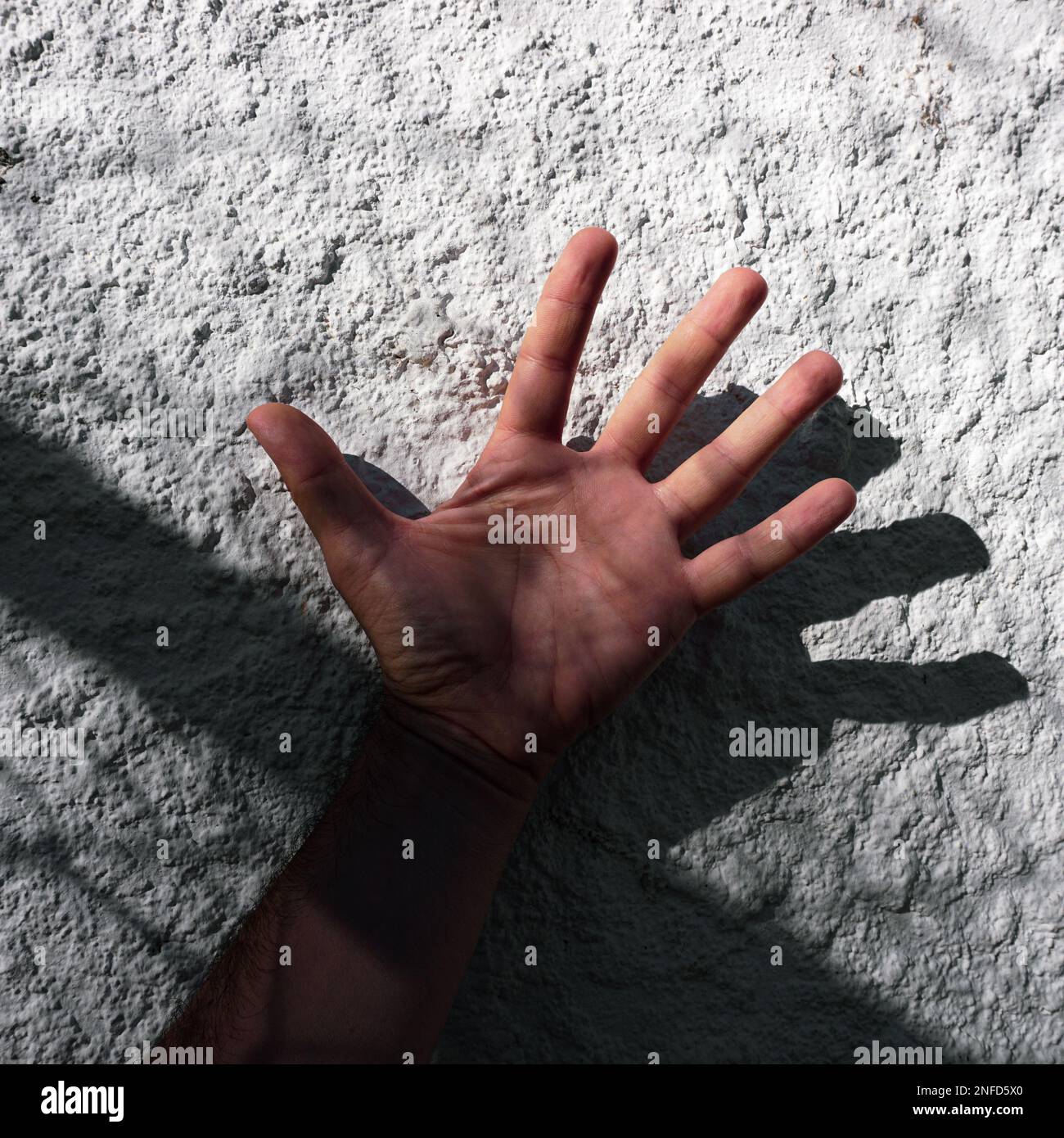 hand on the white wall playing with the shadows Stock Photo - Alamy