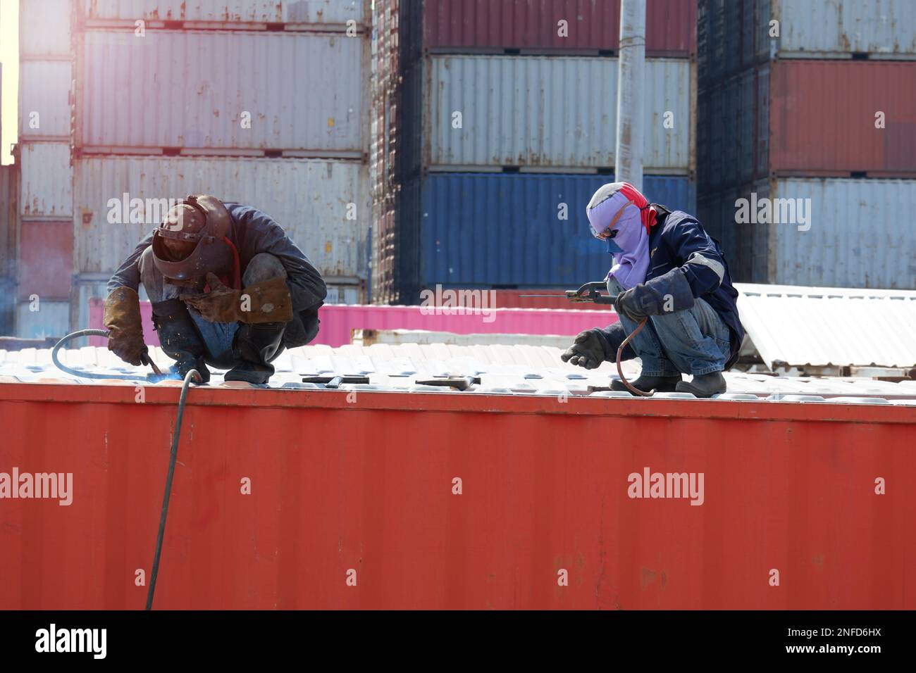 Workers repair damaged container walls Industry at the welding plant is ...