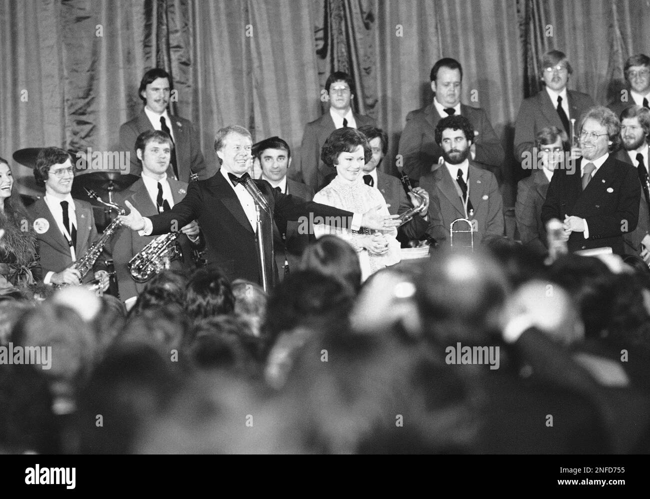 President Jimmy Carter stands with arms extended beside first lady ...