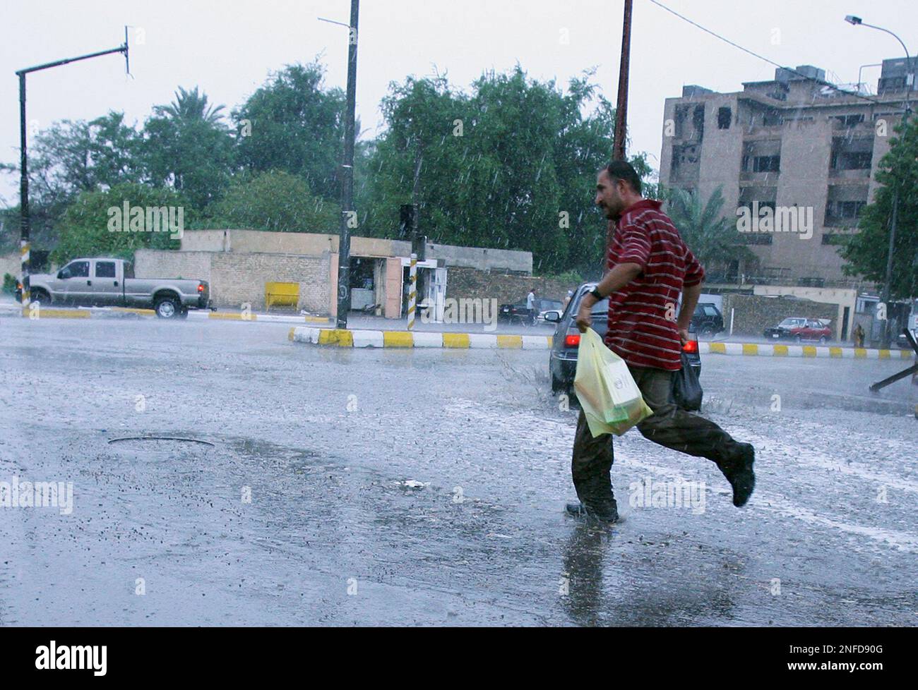 A man runs during a rainfall, in Baghdad, Iraq, on Saturday, Oct. 25 ...