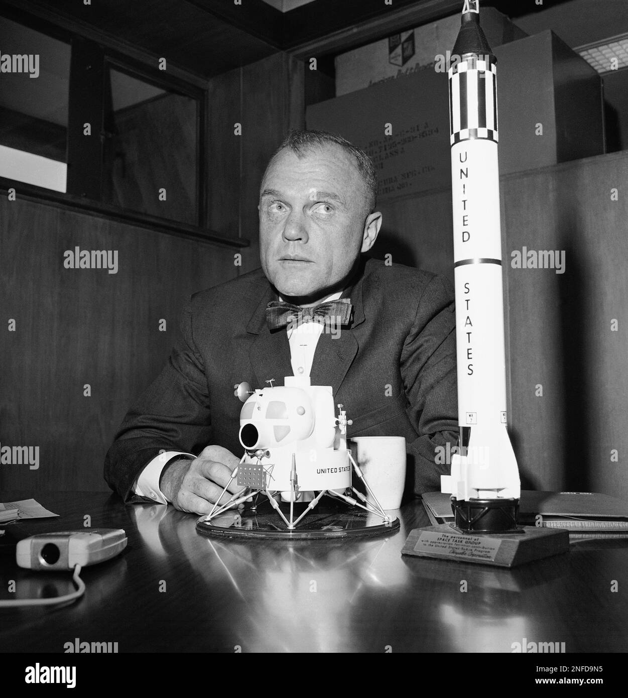 Astronaut John Glenn poses with a model of the Mercury Space Ship atop ...