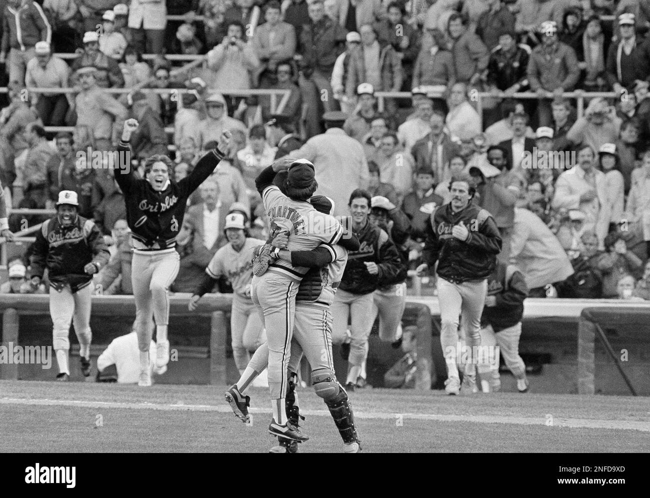 Baltimore Orioles pitcher Tippy Martinez and catcher Rick Dempsey, center, embrace as their ...