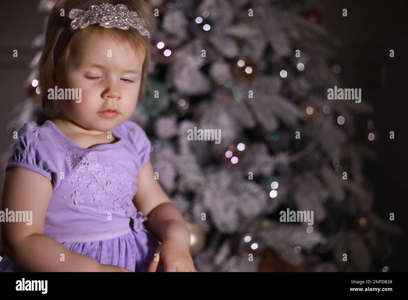 Child in smart clothes in front of the Christmas tree. Waiting for new ...