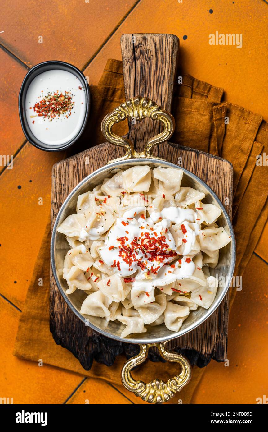 Turkish traditional manti with yoghurt and tomato sauce in a skillet ...