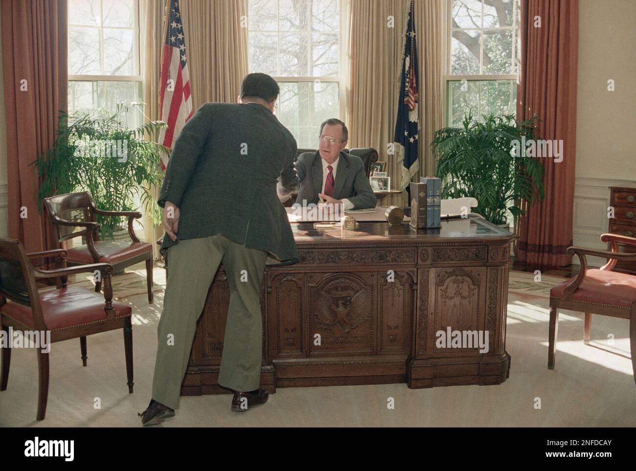 U.S. President George W. Bush sits at his desk in the Oval Office where ...