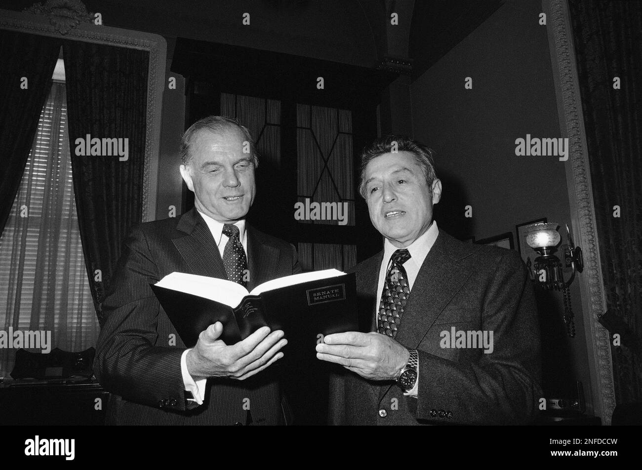 Sen. John Glenn (D-Ohio), left, looks over a copy of the Senate Manual ...