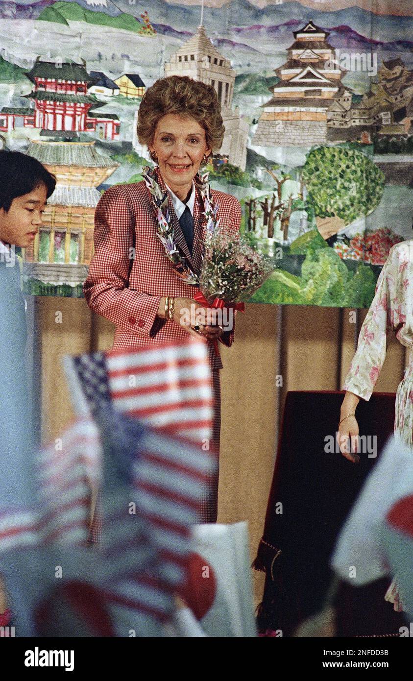 First lady Nancy Reagan holds flowers presented by students during a ...