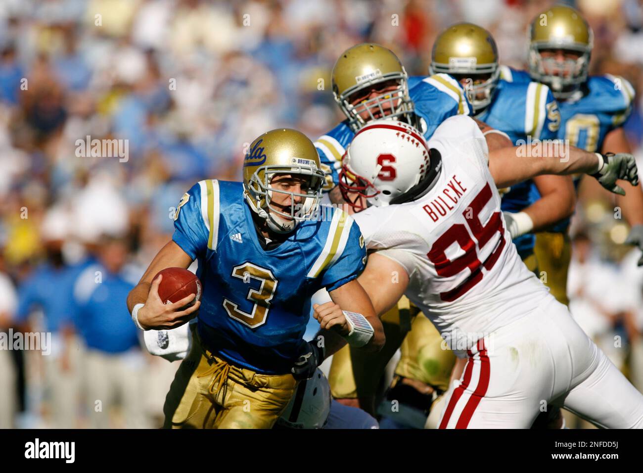 UCLA quarterback Kevin Craft is tackled as Stanford's Brian Bulcke ...