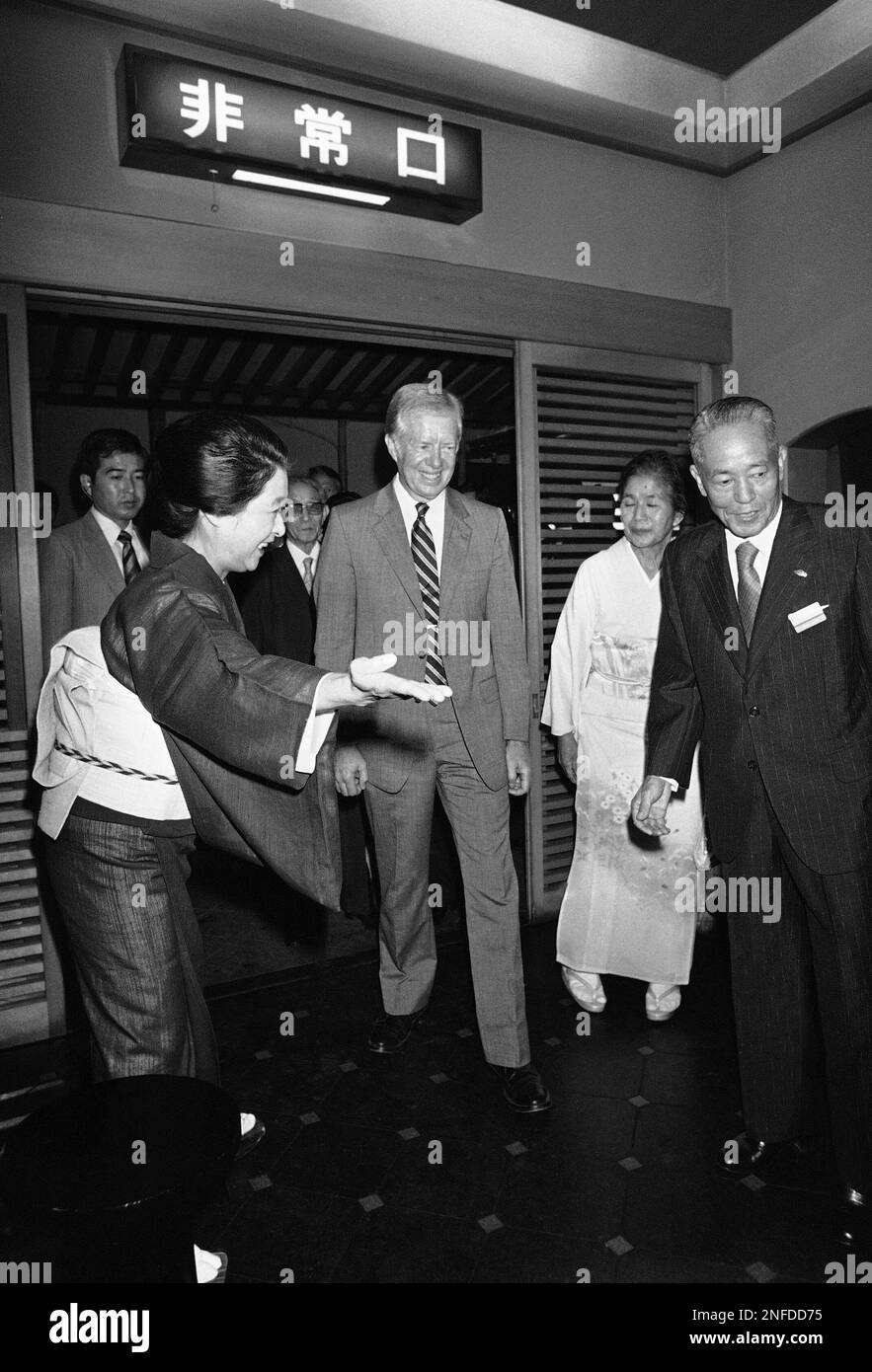 Former U.S. President Jimmy Carter ushered in by a kimono-clad waitress ...